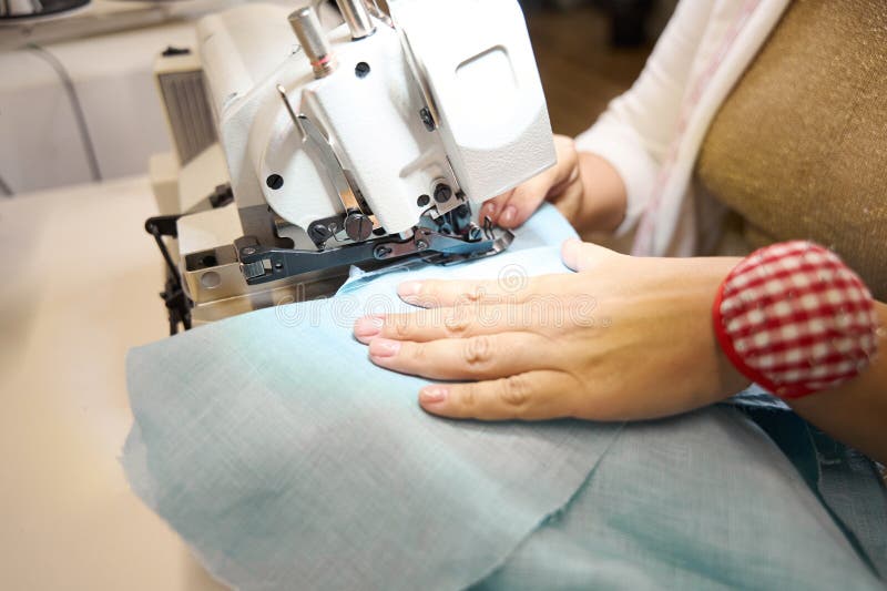 Dressmaker Works on a Sewing Machine with Blue Fabric Stock Image ...