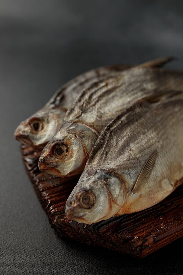 Dried Bream Fish on a Cutting Board on a Black Background Stock Photo ...