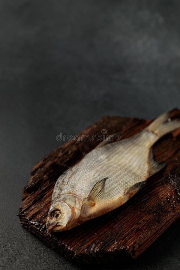 Dried Bream Fish on a Cutting Board on a Black Background Stock Photo ...