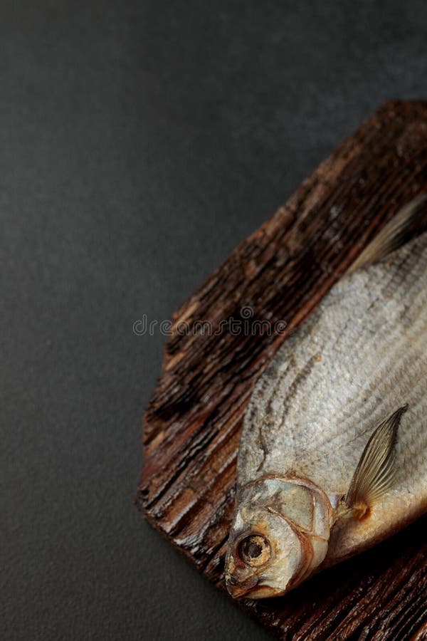 Dried Bream Fish on a Cutting Board on a Black Background Stock Photo ...