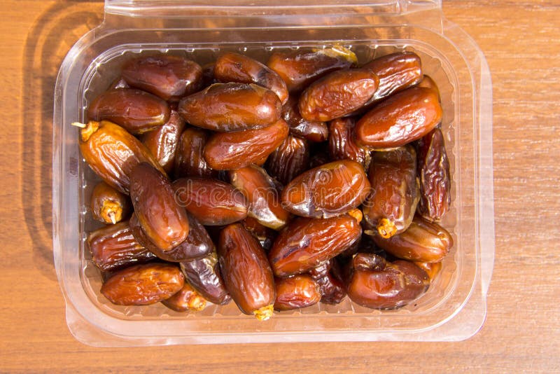 Dried Date Fruits in Plastic Container on Wooden Table Stock Photo ...