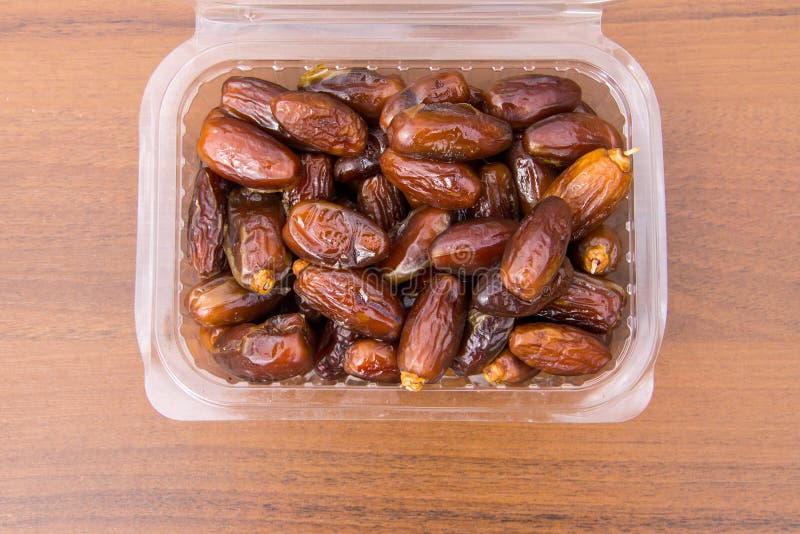 Dried Date Fruits in Plastic Container on Wooden Table Stock Photo ...