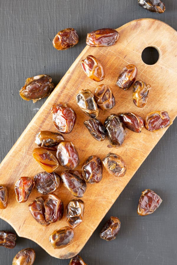 Dried Dates on Rustic Wooden Board on a Black Surface, Top View. Flat ...