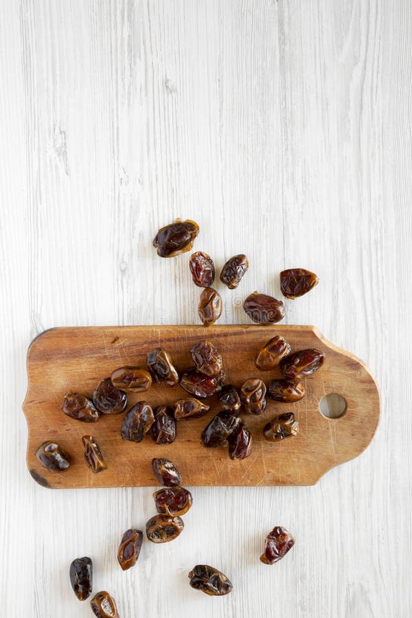 Dried Dates on Rustic Wooden Board on a White Wooden Table, Top View ...