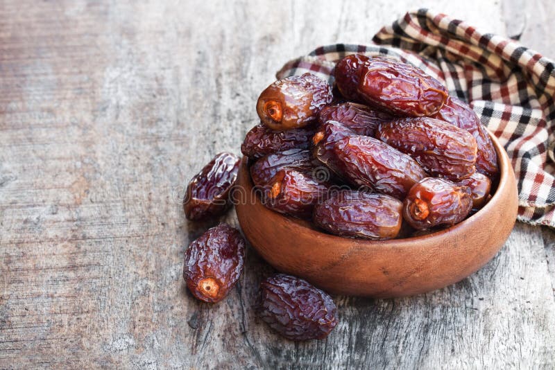 Dried Dates in Wooden Bowl on Rustic Table Stock Image - Image of ...