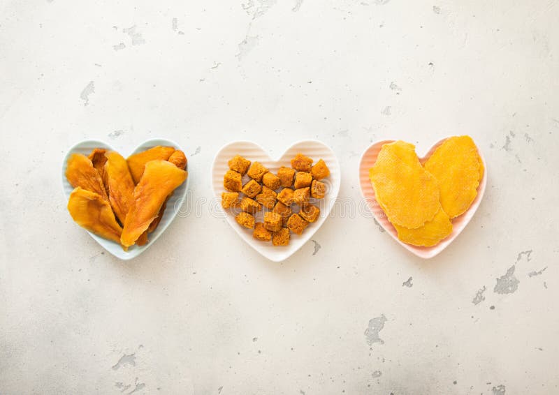 Dried Mango Slices and Balls in Heart Shaped Plates on Light Background ...