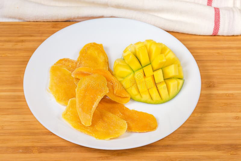 Dried Mango Slices and Fresh Cut Mango Half on Dish Stock Photo - Image ...