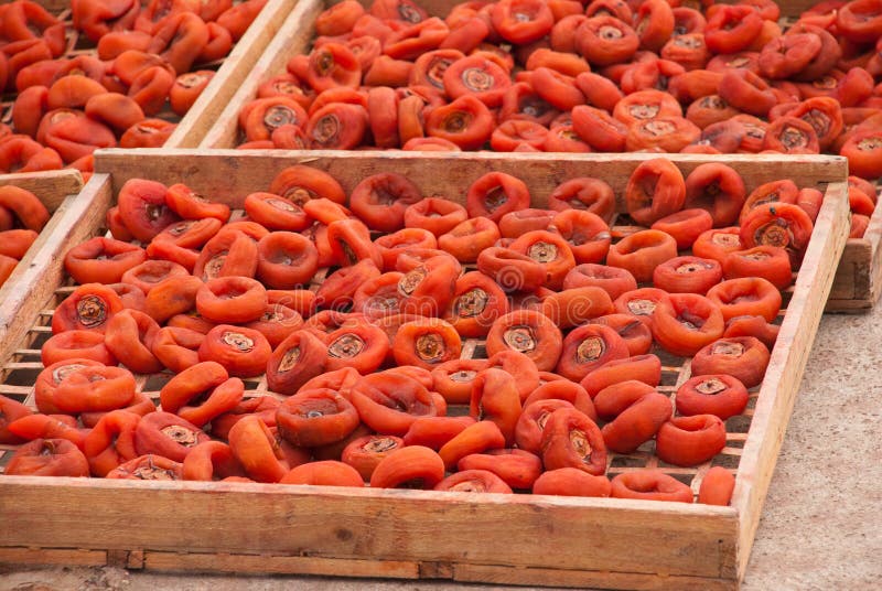 Dried Persimmon with Powdered Sugar Lies on a Stone Dish, on a Dark ...
