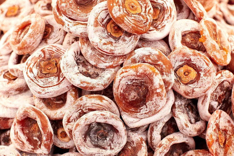 Dried Persimmon with Powdered Sugar Lies on a Stone Dish, on a Dark ...