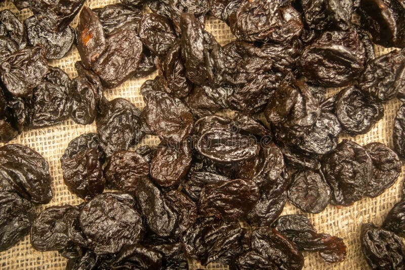 Dried Prunes in Bulk on Burlap with a Rough Texture. Close Up Stock ... Dried Prunes in Bulk on Burlap with a Rough Texture. Close Up Stock ...