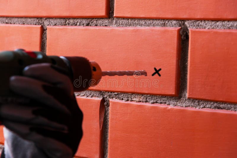 Drill with a Drill on the Background of a Red Brick Wall. on the Brick ...