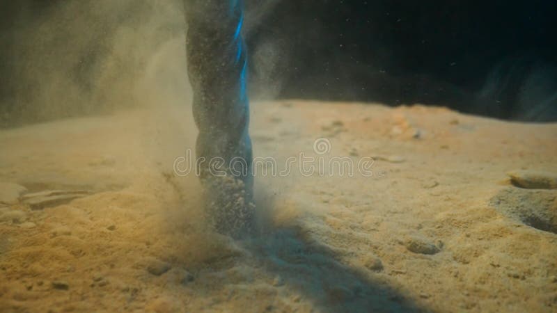 Close Up of Drill Bit Penetrating Sand Surface with Dust Flying Stock ...