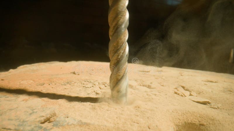 Close Up of Drill Bit Penetrating Sand Surface with Dust Flying Stock ...