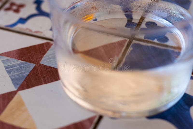 Drinking Glasses with Water and Beer on a Textured Tiled Surface Close ...