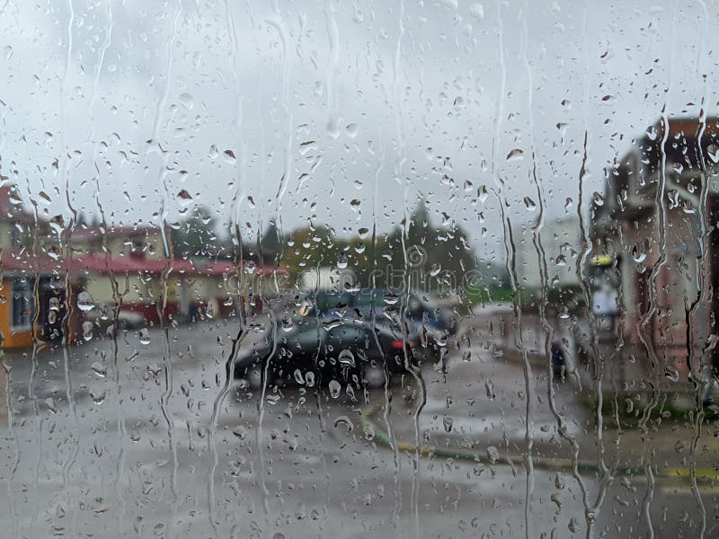 Dripping Rain Drops from Glass on the Background of the City. Stock ...