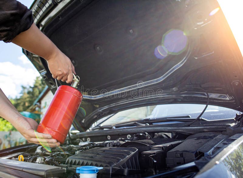 The Driver of the Car Directs a Powder Fire Extinguisher at the Engine ...