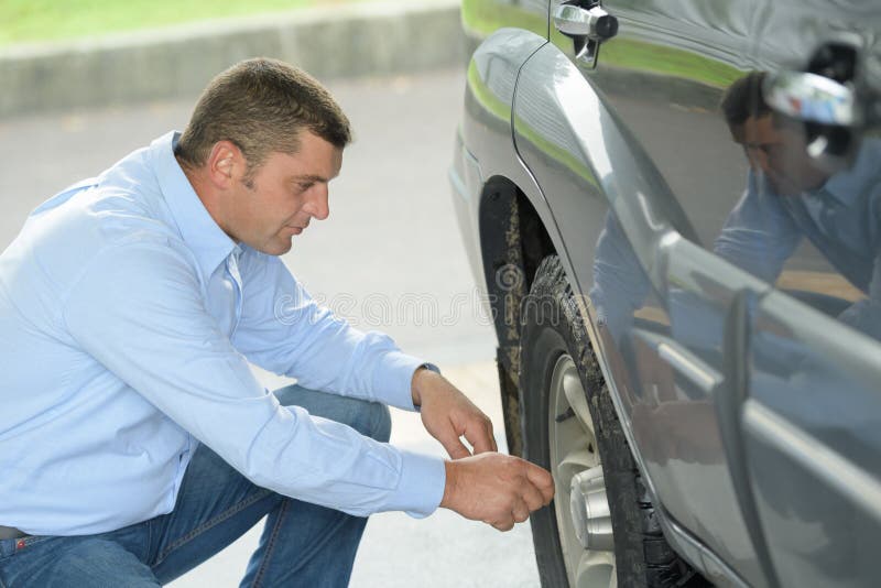 Driver inspecting the tire stock photo. Image of tube - 258798658