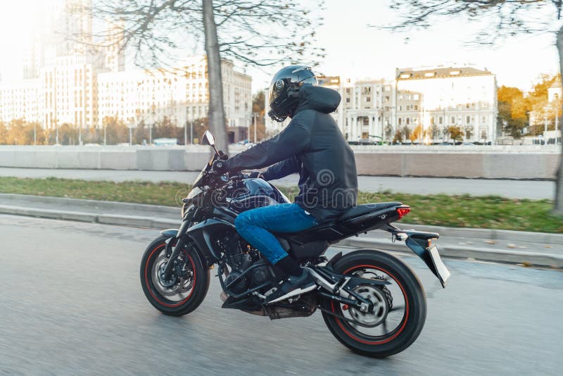 Driver Riding Motorcycle on Empty Road Out of the City at Beautiful ...