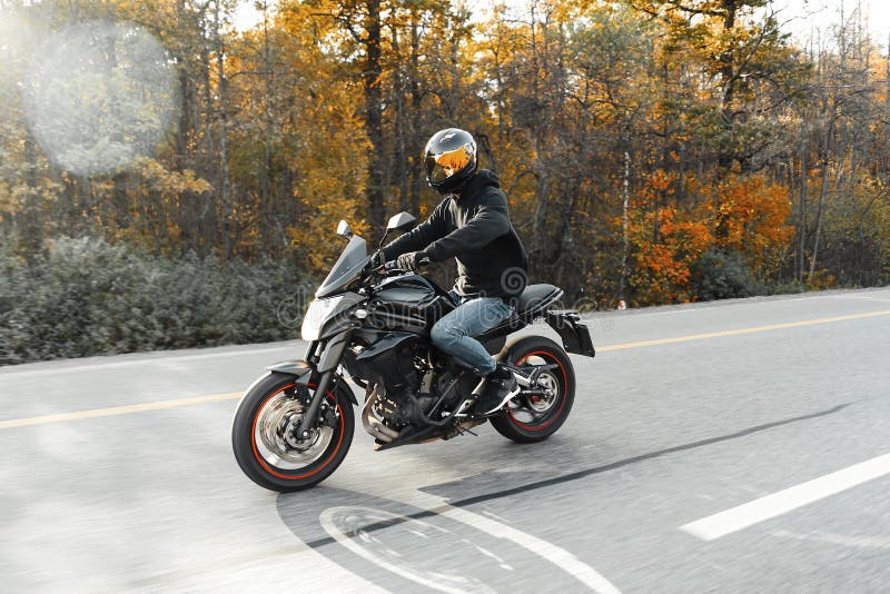 Driver Riding Motorcycle on Empty Road in Beautiful Autumn Forest ...
