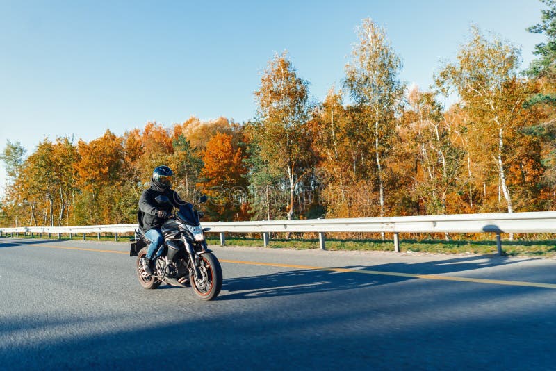 Driver Riding Motorcycle on Empty Road in Beautiful Autumn Forest ...