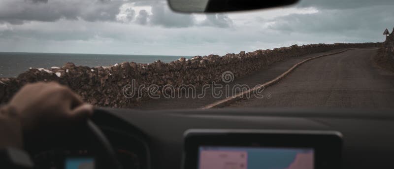 Driving Along a Rocky Road Along the Coast of the Ocean. Driving a Car ...