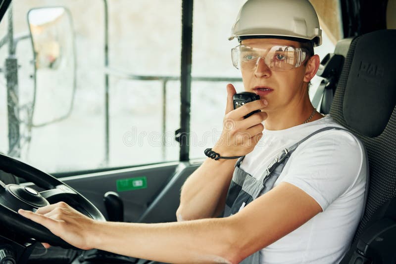 Driving Transport. Worker in Professional Uniform is on the Borrow Pit ...