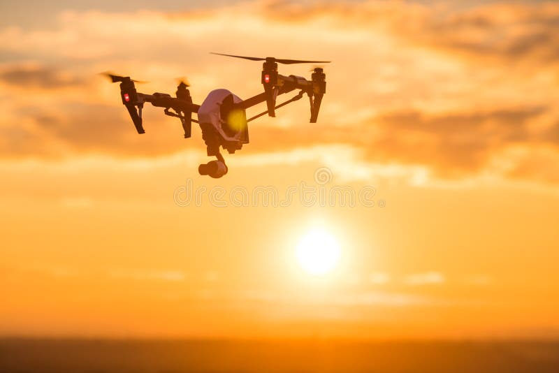 Drone with Digital Camera Flying in Sky Over Field on Sunset Stock ...