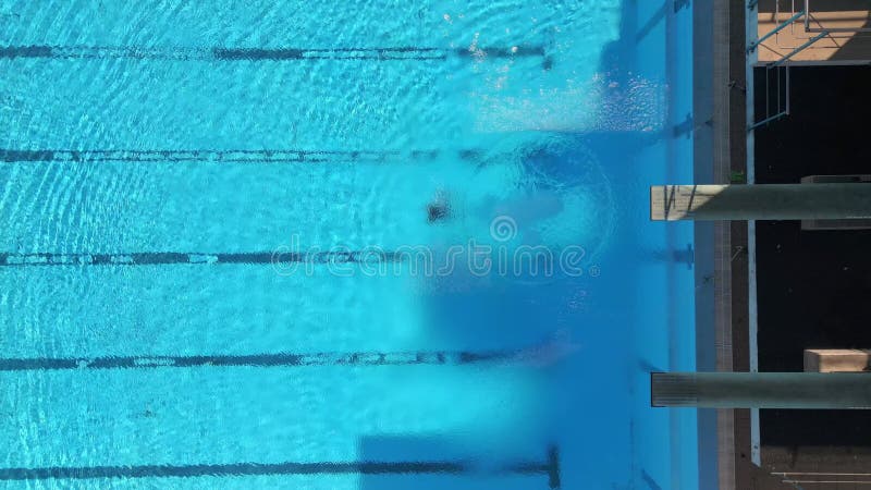 Drone Footage Capturing a Diver Mid-air Performing a Tuck Dive Above a ...