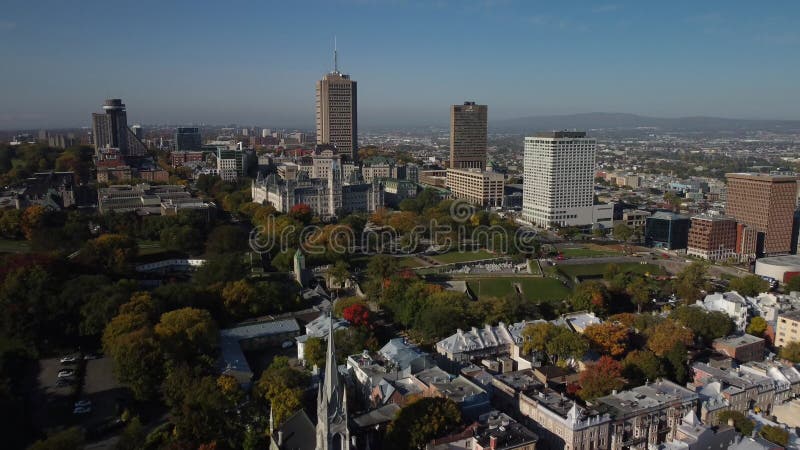 Drone Footage of Cityscape with Towers and Buildings with Trees in the ... Drone Footage of Cityscape with Towers and Buildings with Trees in the ...