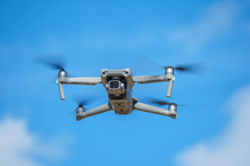 A Drone with a High-resolution Digital Camera Flies Against a Blue Sky ...