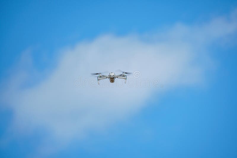 A Drone with a High-resolution Digital Camera Flies Against a Blue Sky ...