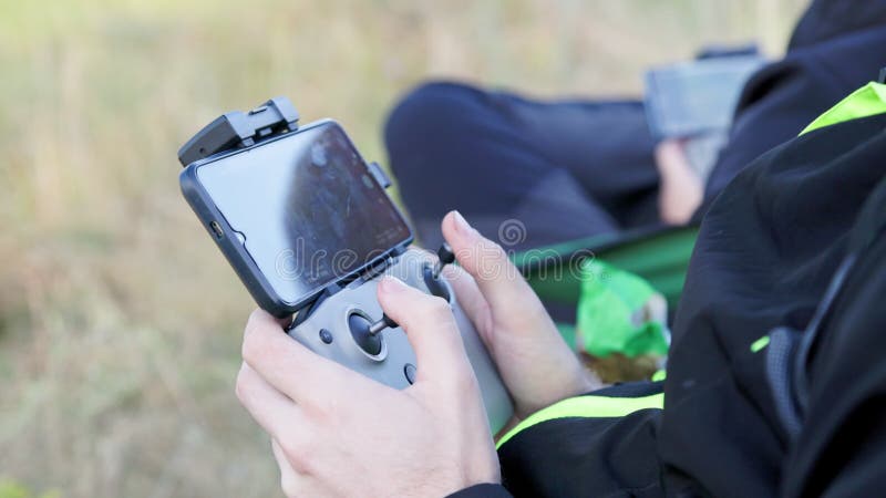 Drone Operator Hands Using Remote Control with Sticks and Cellphone As ...