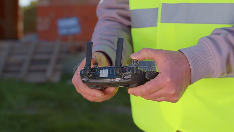 Drone Operator Holding Remote Controller Controls an Aircraft in Front ...