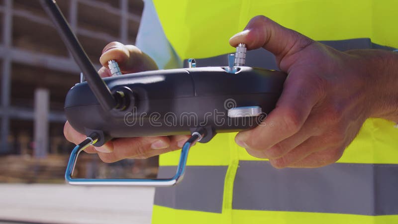 Drone Operator Holding Remote Controller. Professional Builder in Helmet and Vest Standing in ...