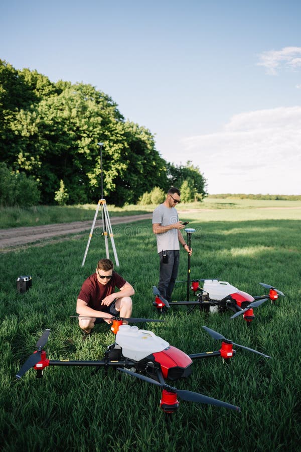 A Drone Pilot Configuring His Drone in a Field with and Irrigation ...
