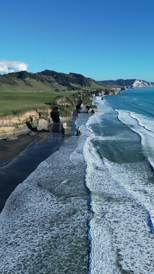 Drone Pullback of the Blue Sea with Green Rocky Shore at the Three ...