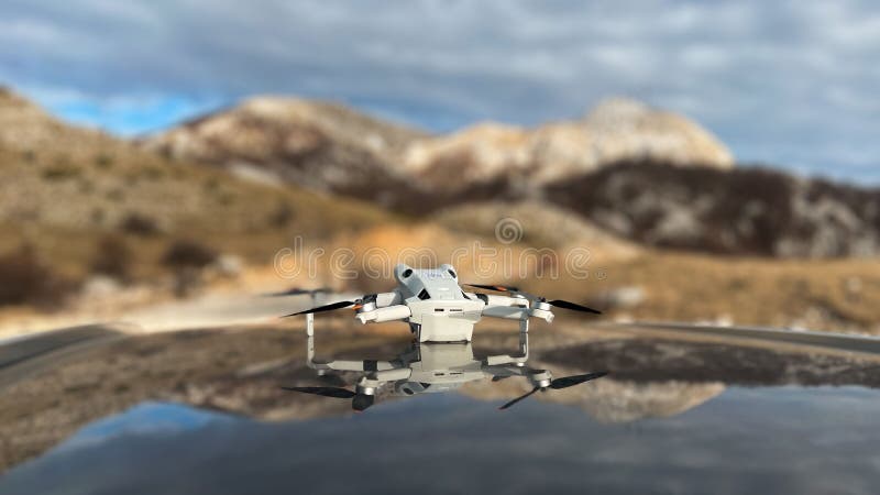 Drone on Reflective Surface with Mountain Backdrop. Stock Image - Image ...