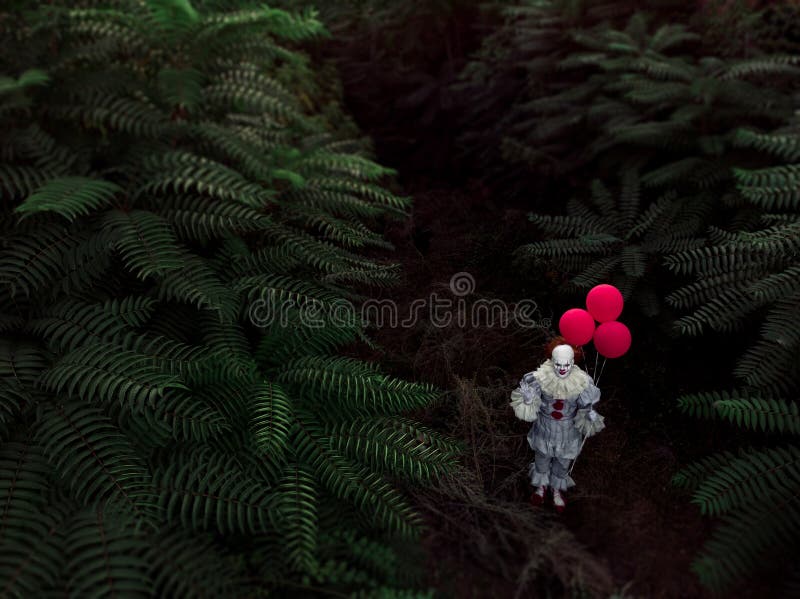 A Drone Shot of a Clown with Red Balloons in the Forest Stock Photo ...