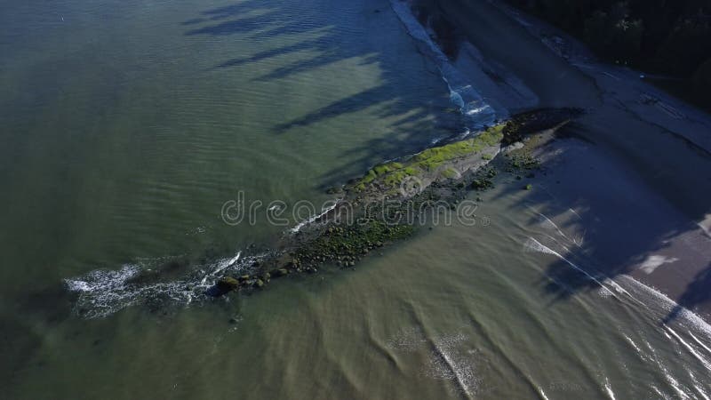 Drone Spins and Rises Over the Water Waves Touching the Sandy Shore ...