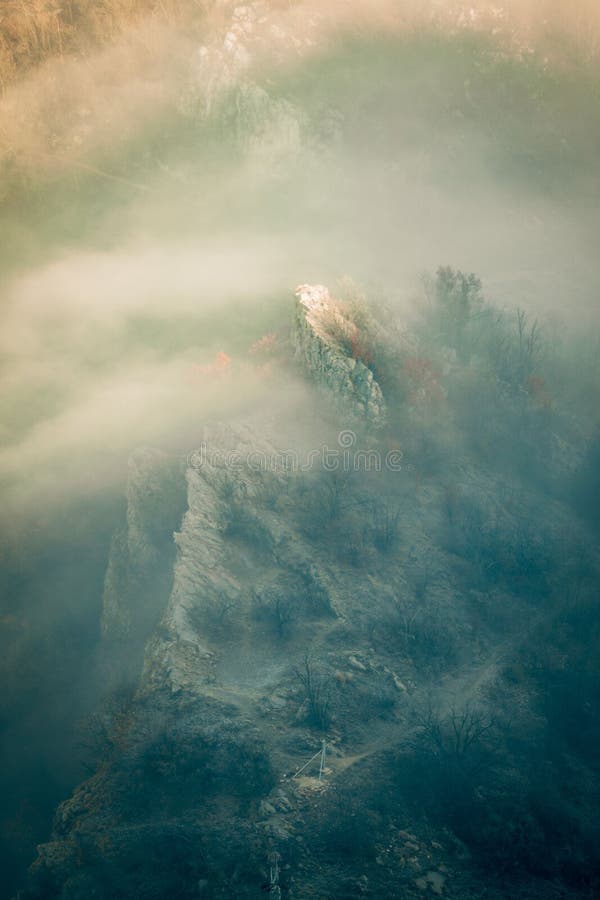 Drone Vertical Shot of a Rocky Peak Hidden in a Heavy Mist Stock Photo ...