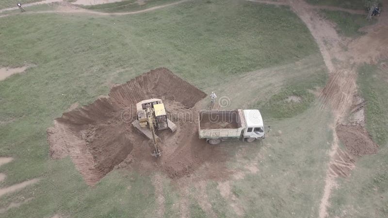 Drone View of an Excavator Loading Earth into a Small Truck at Open ...