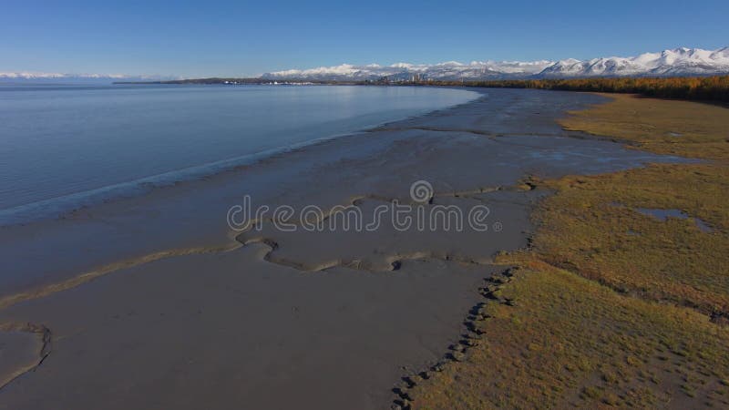 Drone View of the Jetty Rocks in a Sea with Snowy Mountains in the ...