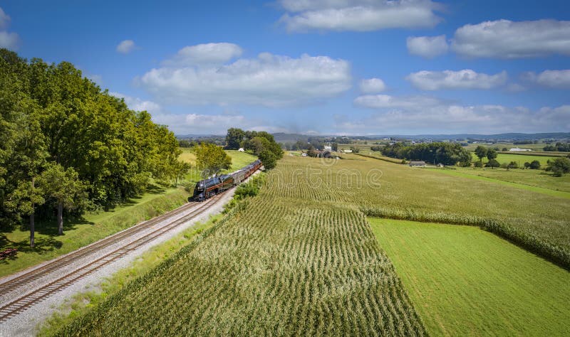 Drone View of a Steam Passenger Train Approaching a Track Switch with ...