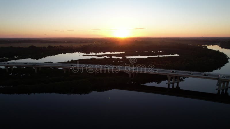 Drone View of Vehicles Driving Over the Fort Hamer Bridge Reflected in ...