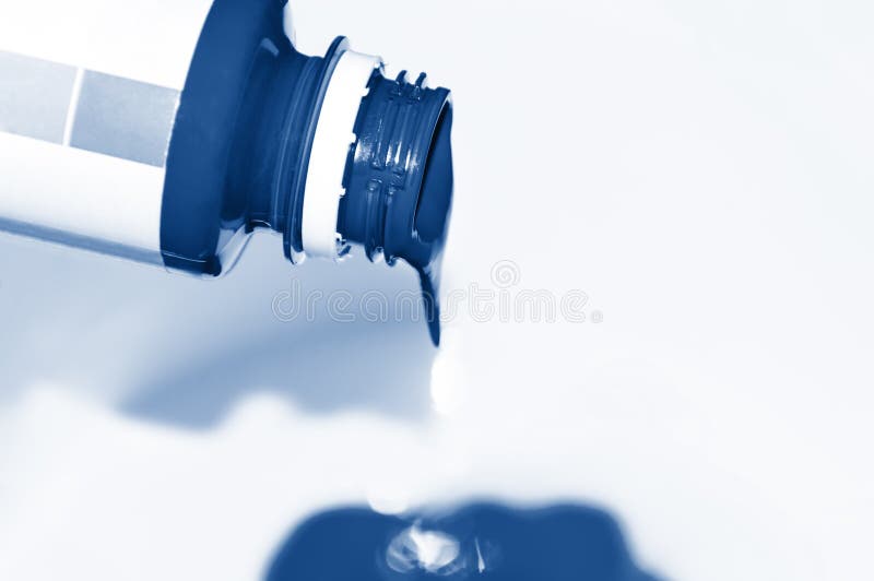 A Drop of Classic Blue Paint Falling from the Bottle on White ...