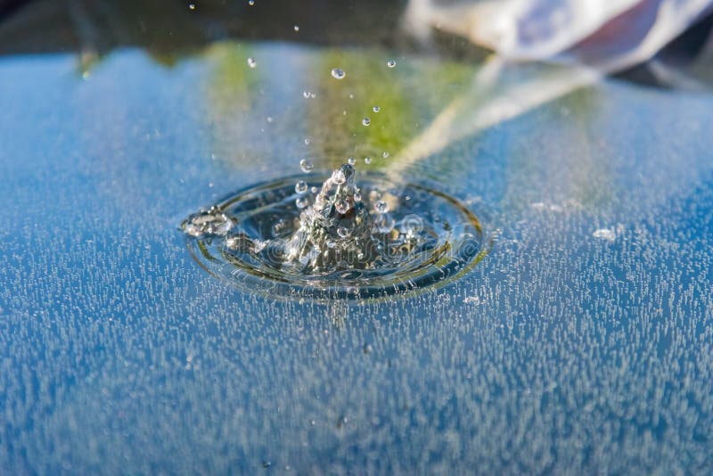 A Drop Falling into the Water in a Container Against the Background of ...