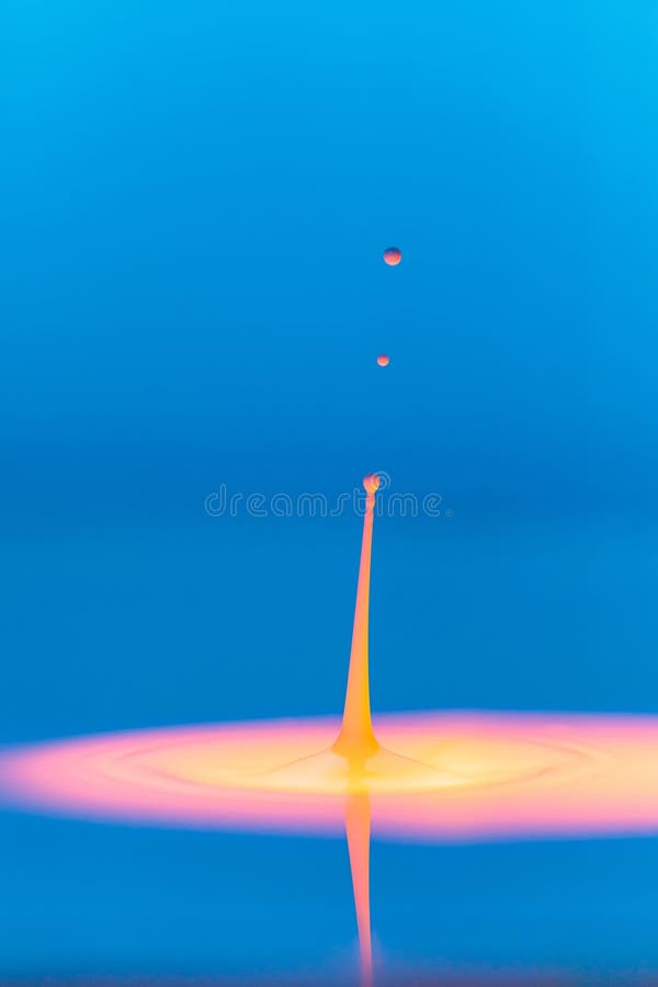 A Drop Falls into a Thick Liquid with a Blue-yellow Background ...