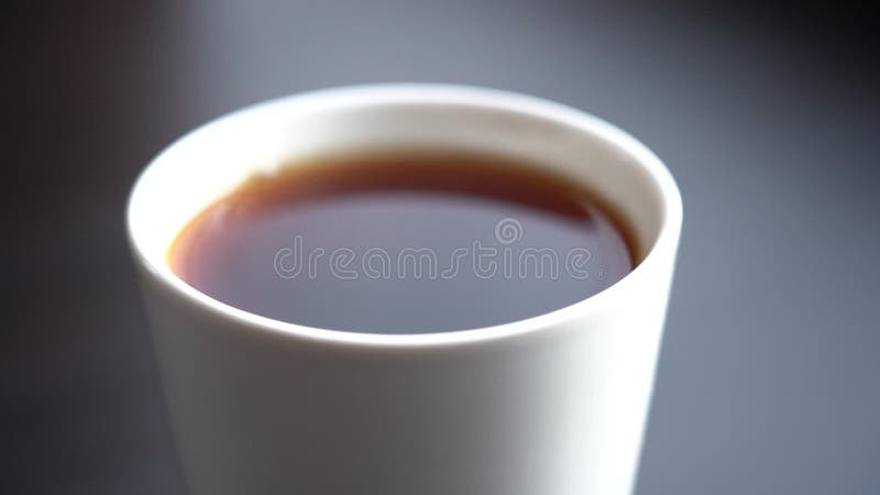 A Drop Falls into a White Mug with Black Tea on a Black Table in ...