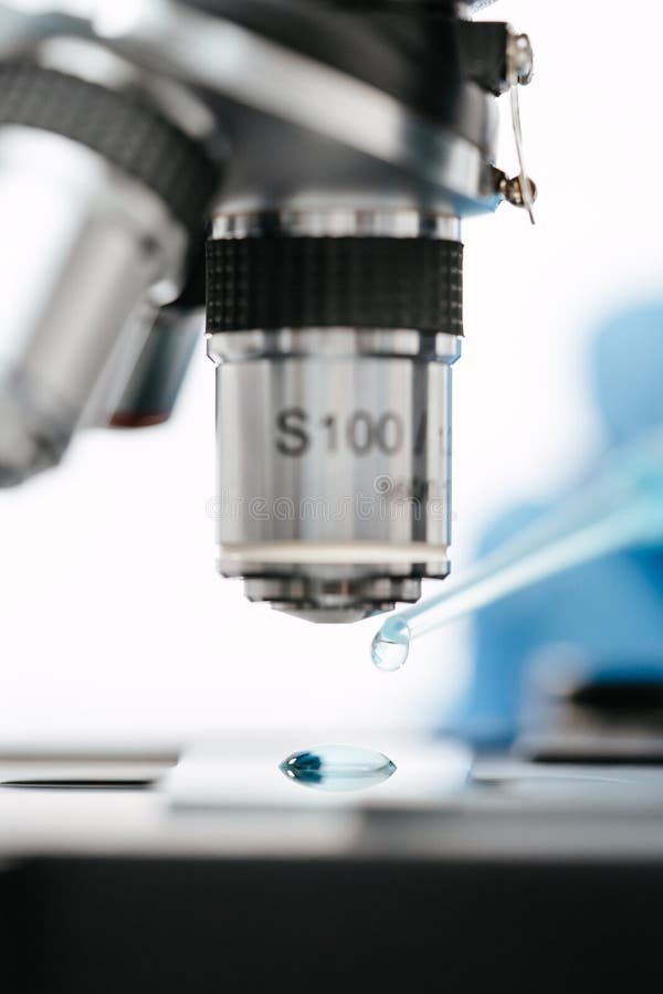 Drop of Blue Liquid on Slide at Microscope To Make Coronavirus Test in ...