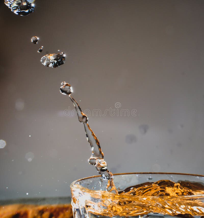 Drop Splashing Orange Water Falling Against Gray Background Stock ...